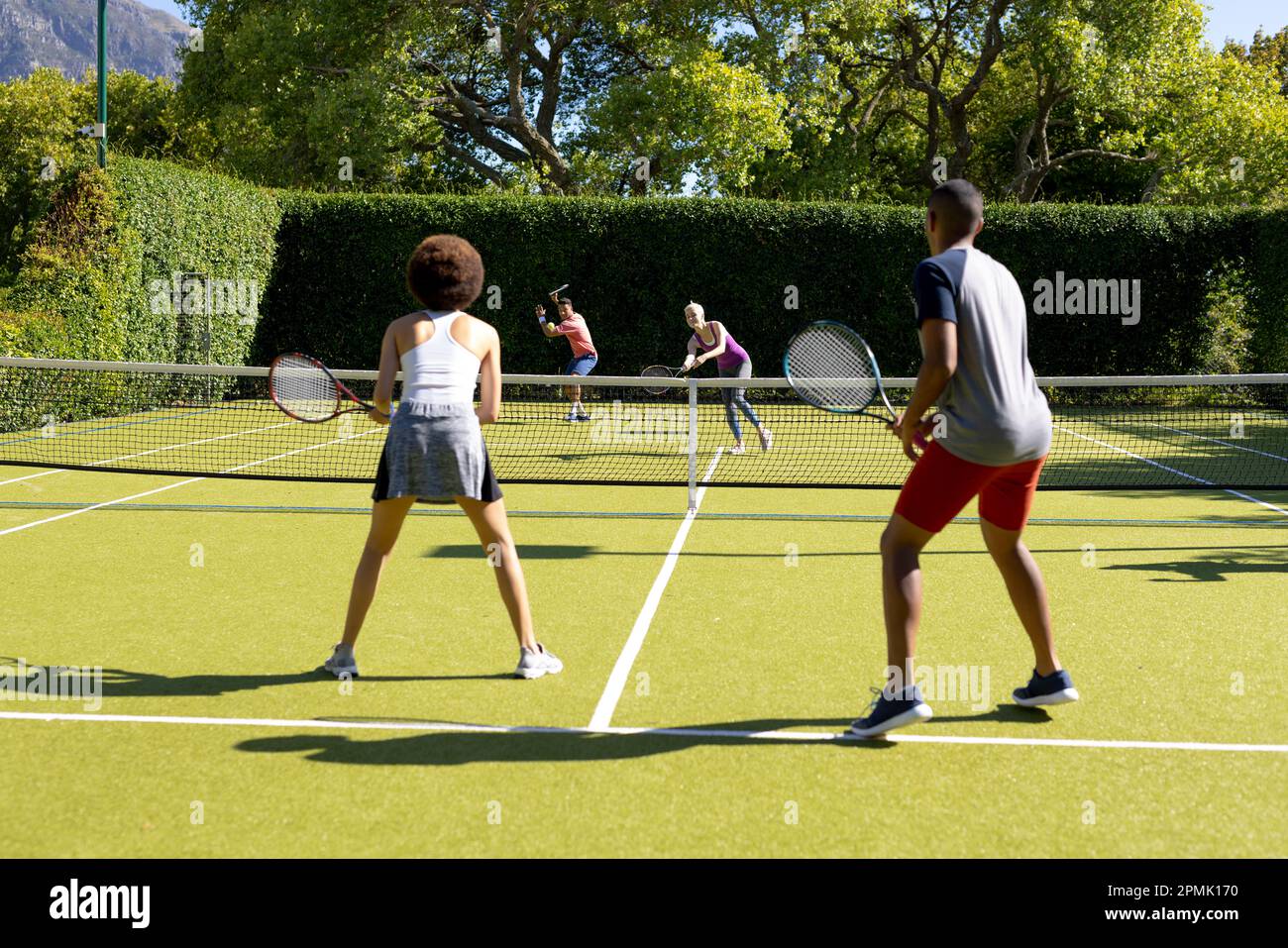Happy diverse group of friends playing tennis at tennis court Stock ...