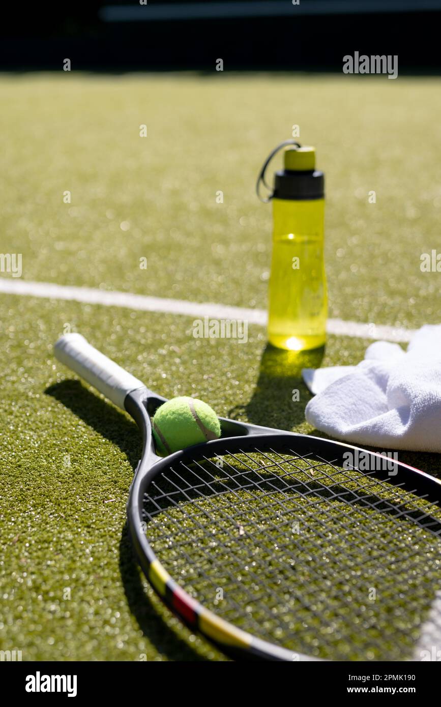 Close up of tennis ball, racket, towel and water bottle at tennis court ...