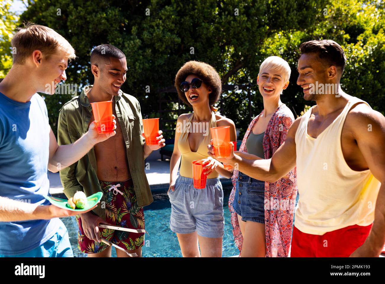 Happy diverse group of friends having pool party, making a toast in ...