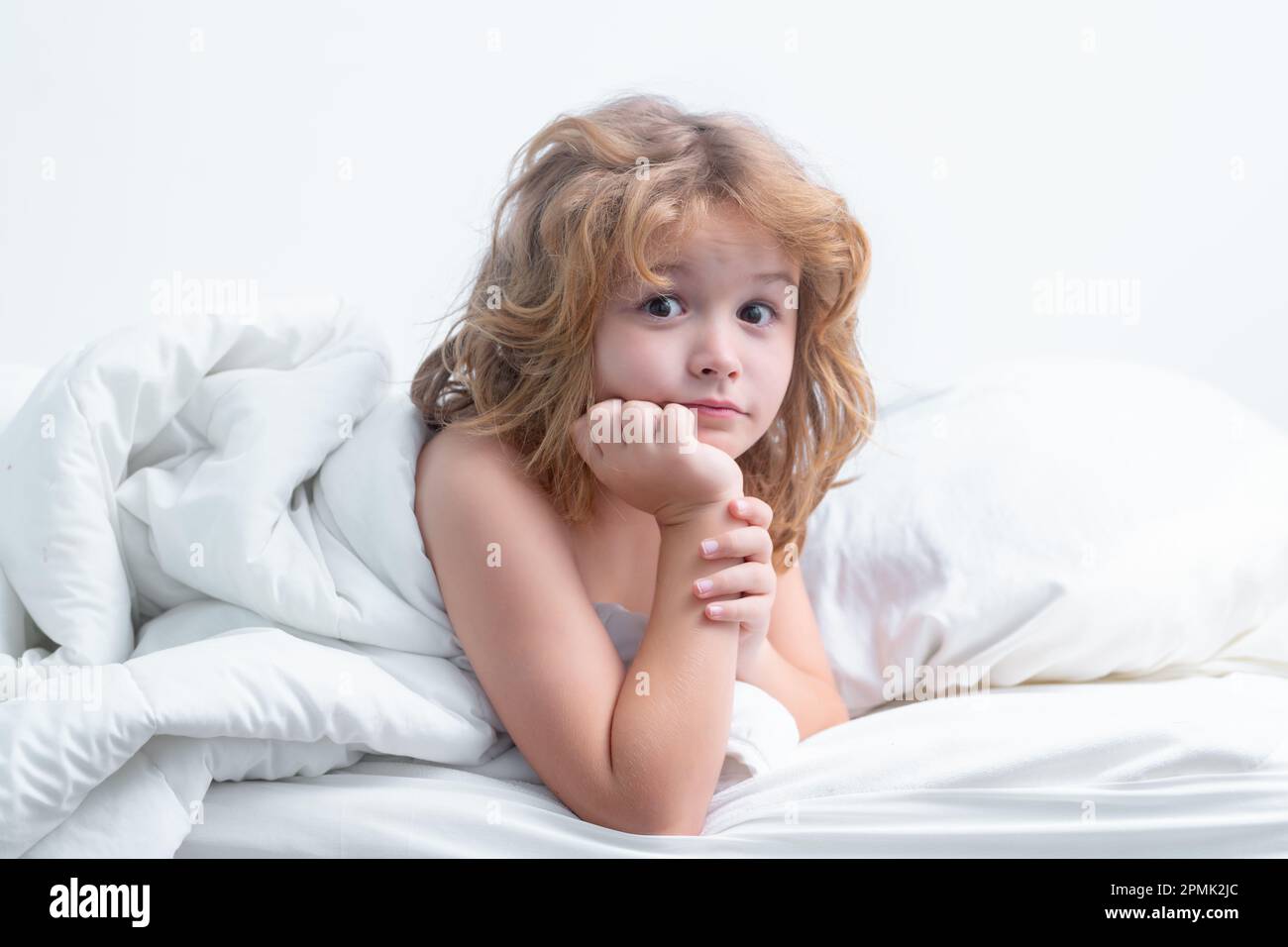 Morning awakening little child in bed. Kid wakes up in the bedroom ...