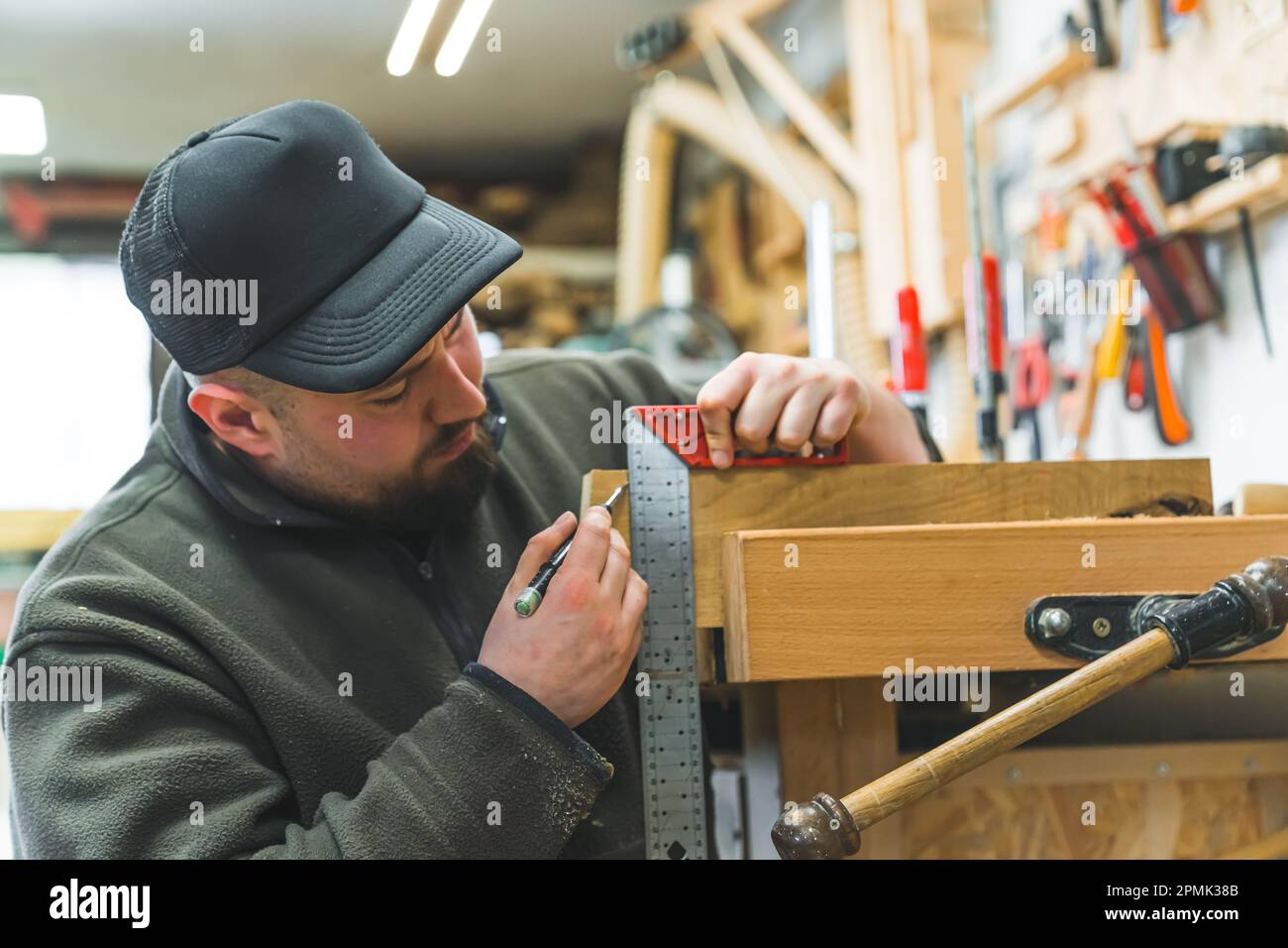 Tools in woodworking process. Focused craftsman using bracket and ...