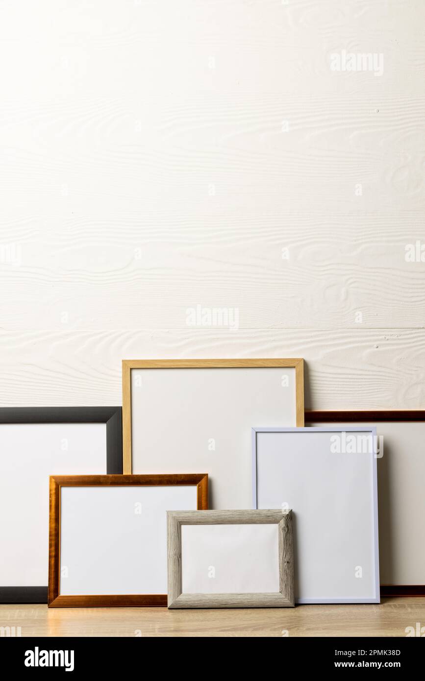 Vertical of six various empty frames with copy space on table against ...