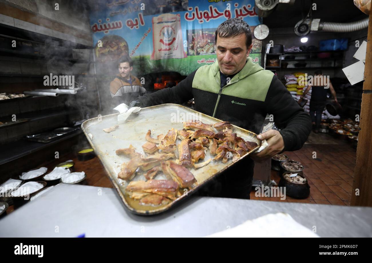 Hebron. 13th Apr, 2023. Palestinian bakers prepare traditional food ...