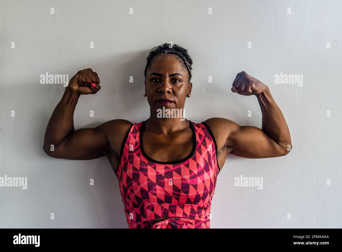 Beautiful woman showing upper muscles. isolated on white background ...