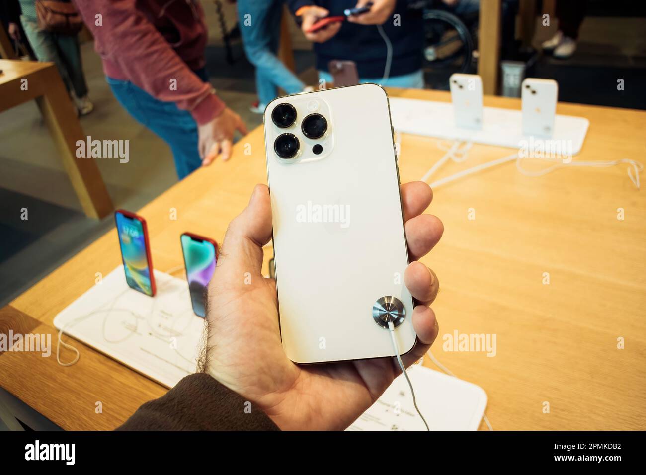 Paris, France - Sep 22, 2022: male hand holding new golden Apple iPhone ...