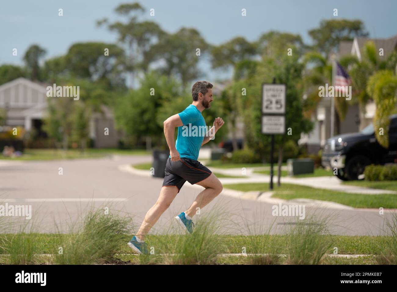 Handsome middle aged man running across american neighborhood. Athletic ...