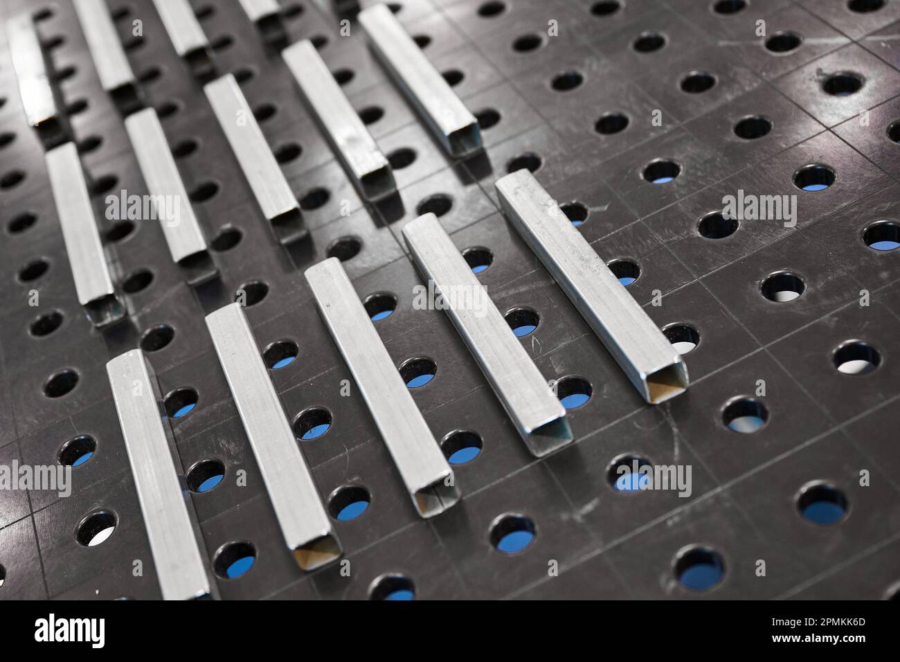 Square metal tube pieces rows on steel surface in workshop Stock Photo ...