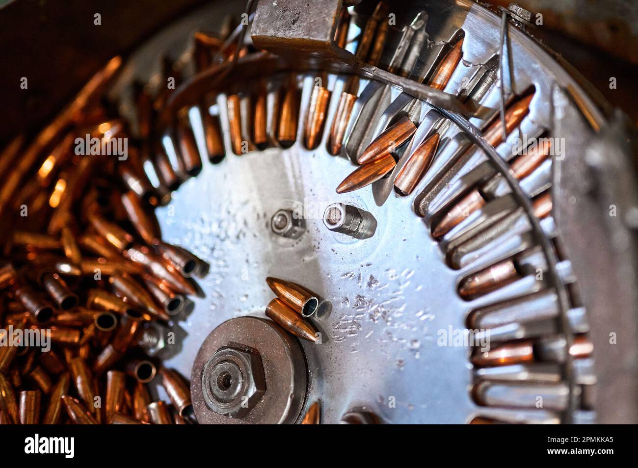 Pile of orange bullets and turning wheel at production line Stock Photo ...