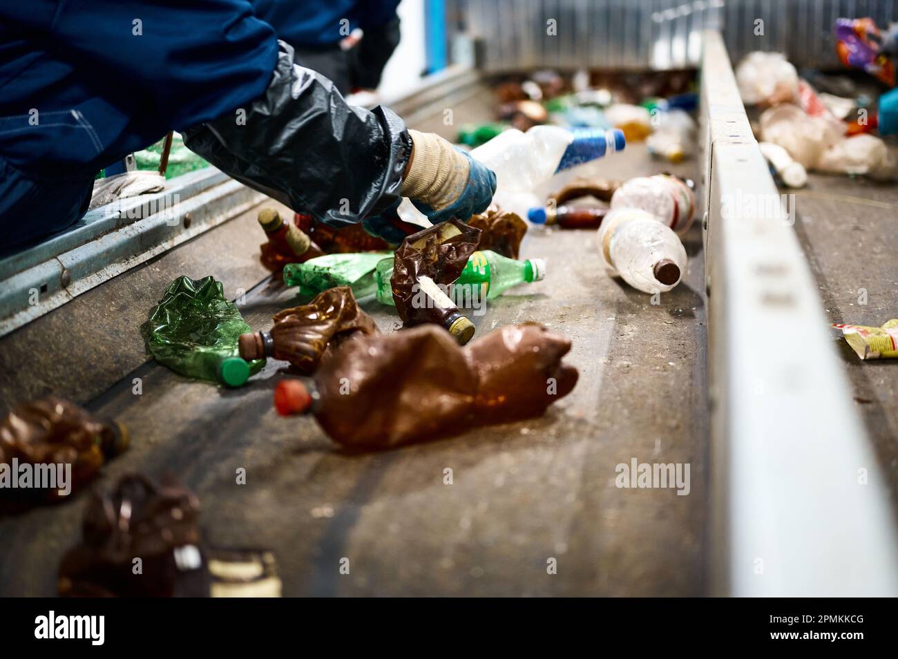Worker sorts trash on conveyor belt at waste recycling plant Stock Photo - Alamy