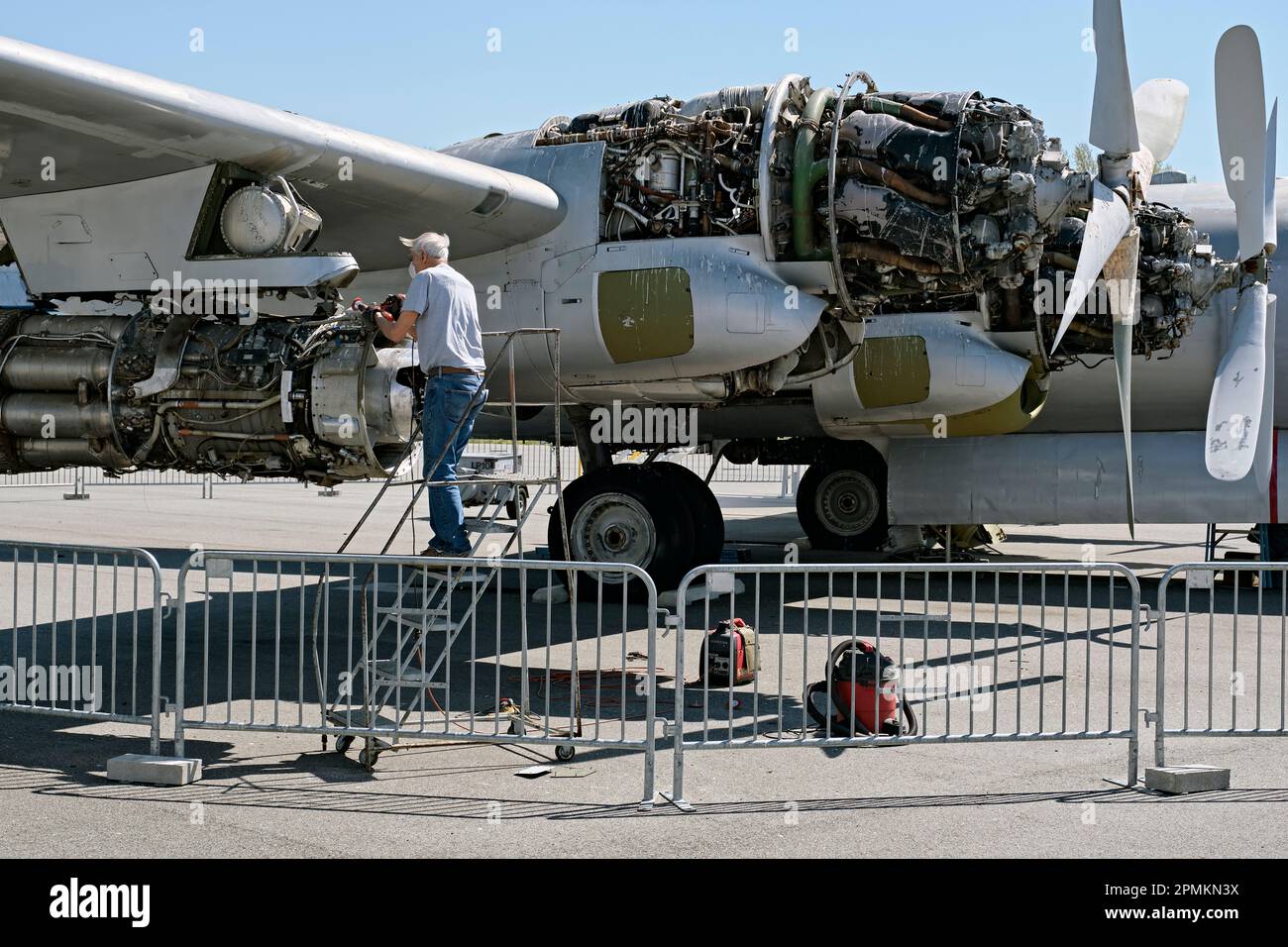 An mechanic rebuilds a vintage military propeller driven aircraft at ...
