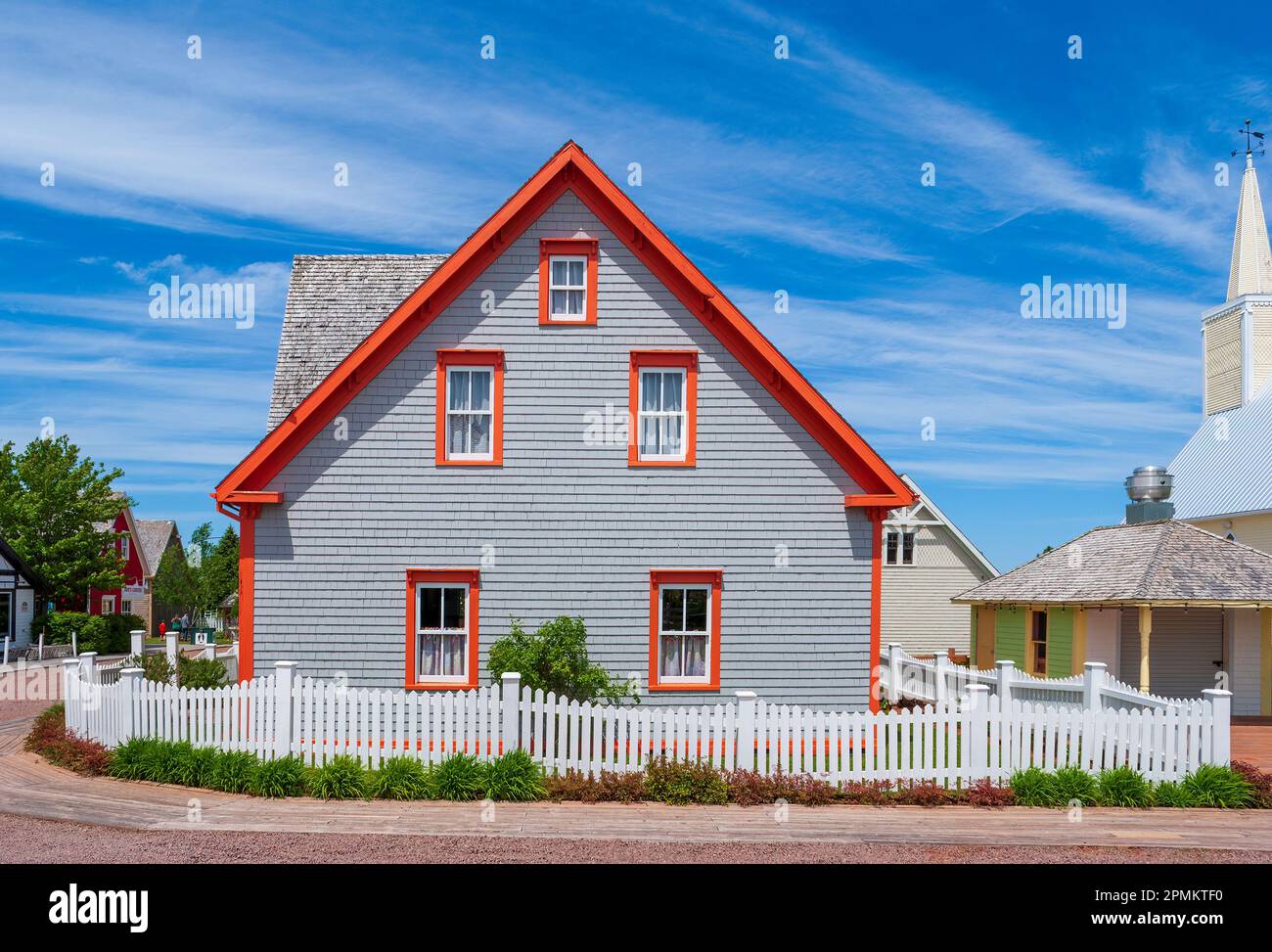 Side-gabled dwelling with orange trim accents that pop against the blue ...