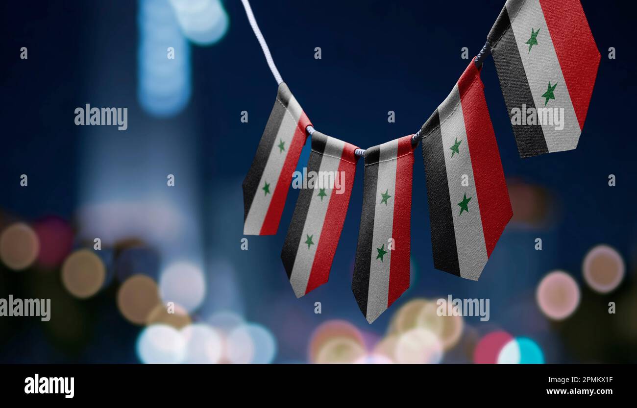 A garland of Syria national flags on an abstract blurred background ...