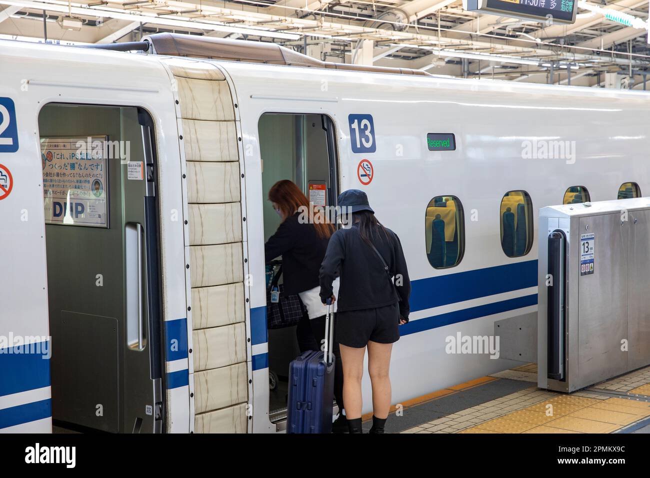 April 2023 two female passengers board the bullet train Shinkansen at Tokyo station in Japan ...