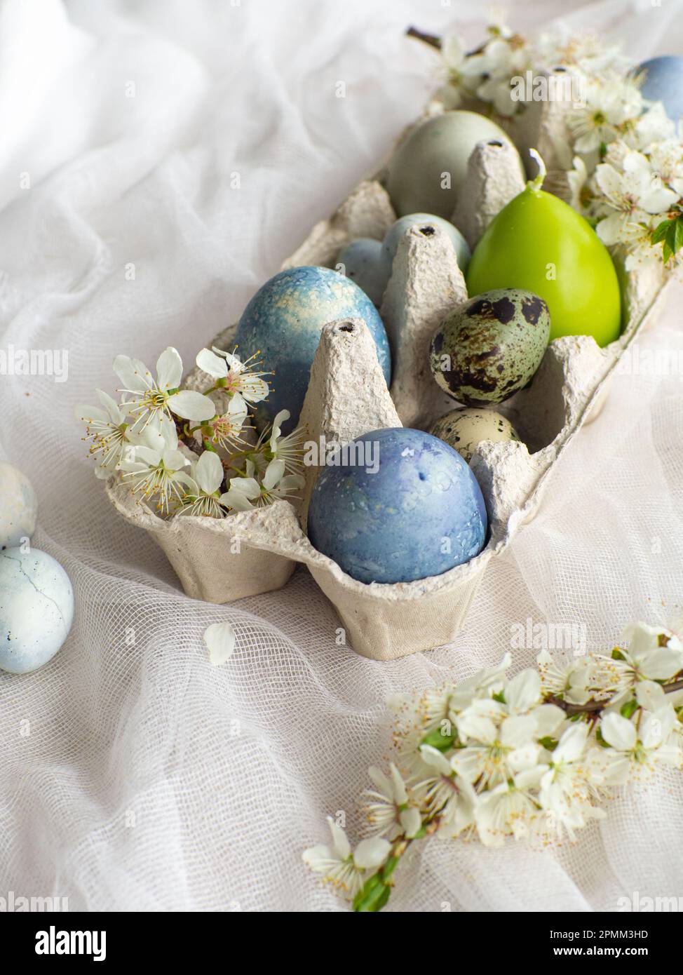 Blue painted easter eggs and candle in tray. Dyed Easter eggs with ...