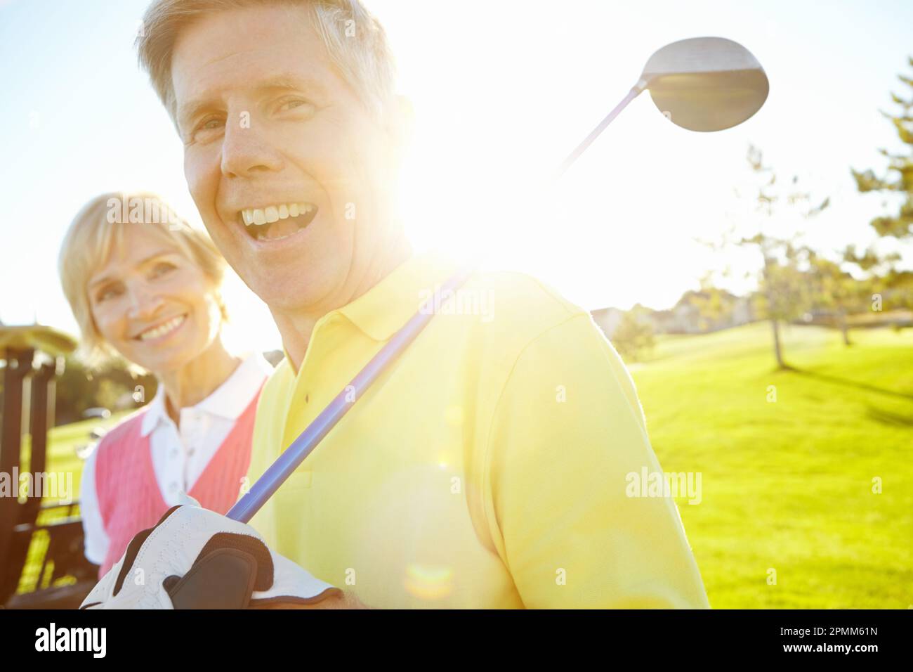 Relaxing on the golf course is the best. Attractive elderly couple with ...