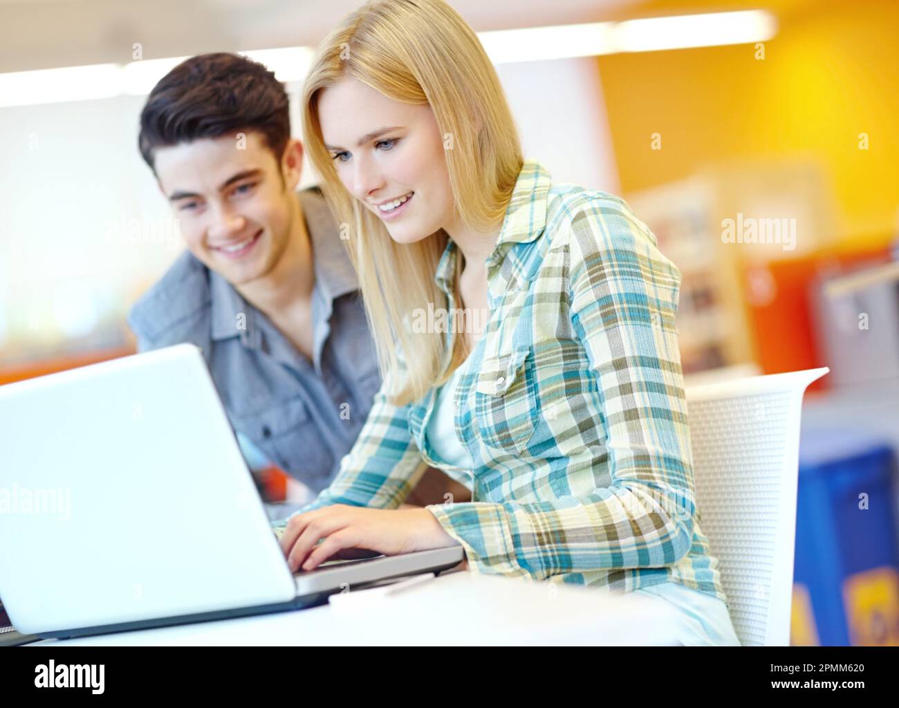 Working together to get the project done. Two smiling students helping ...