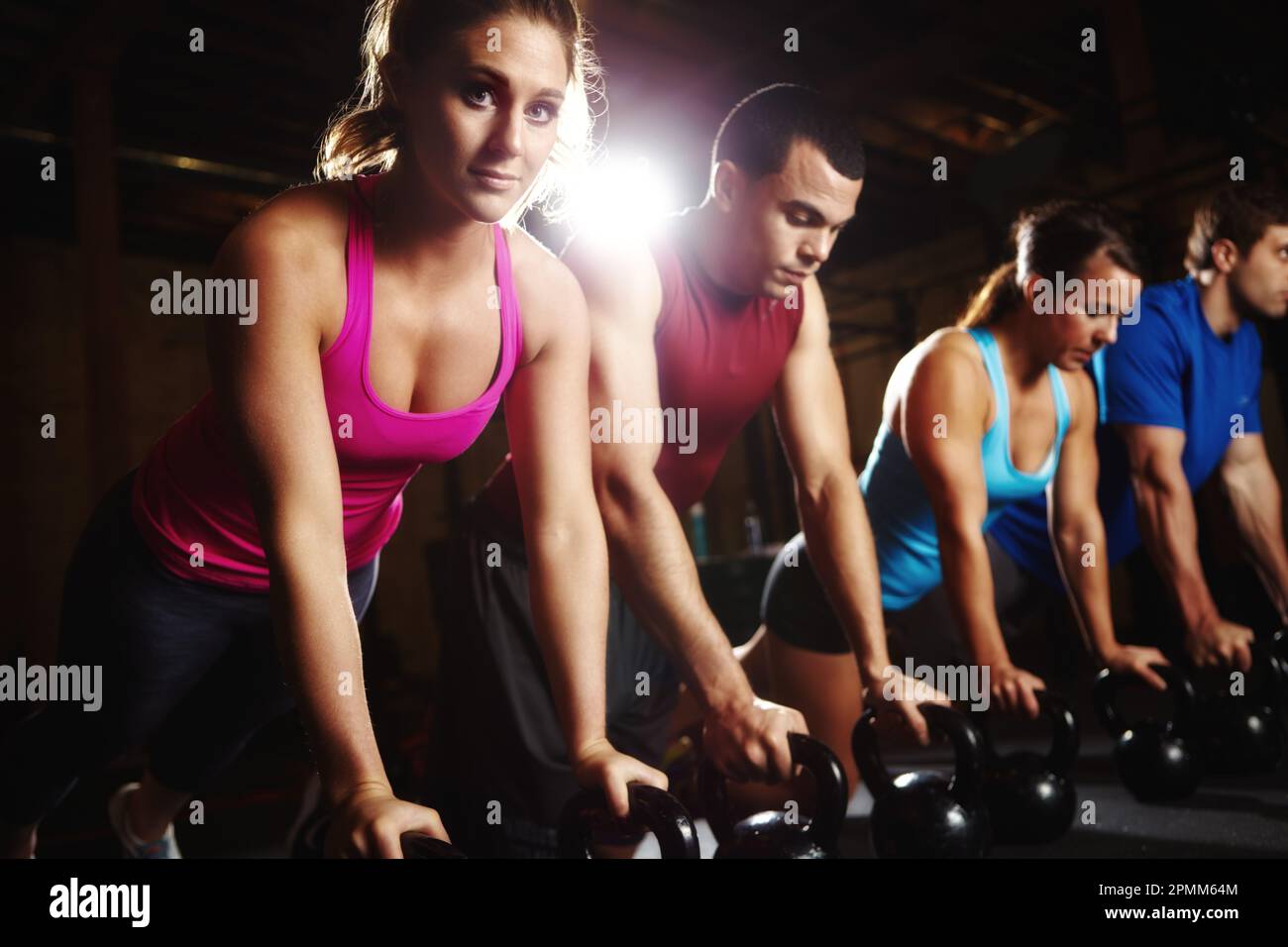 Some serious muscle training. A group of young men and women attending ...
