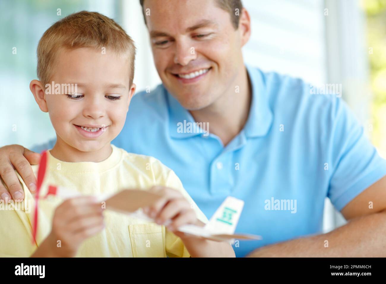 Building a model plane with dad. a father and son assembling a model ...