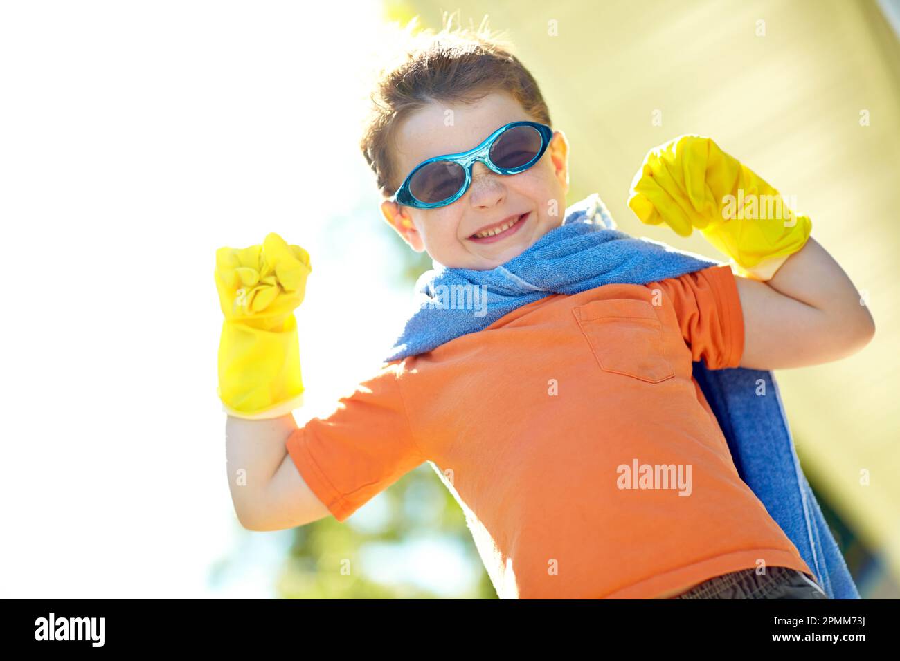 Power up before battle. A playful little boy dressed as a superhero at ...
