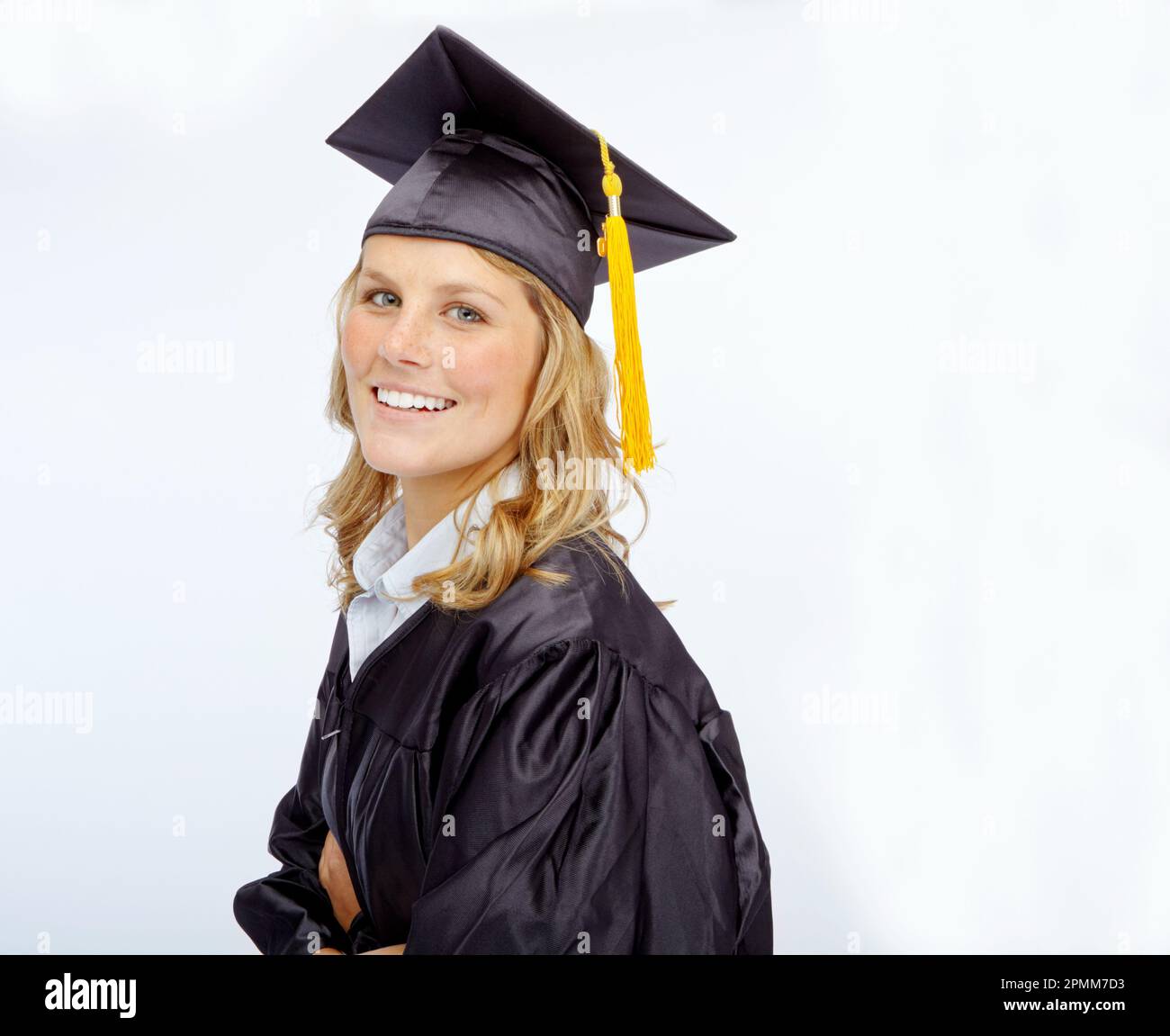 Her future looks bright. Cap and gown-clad young woman smiling while ...