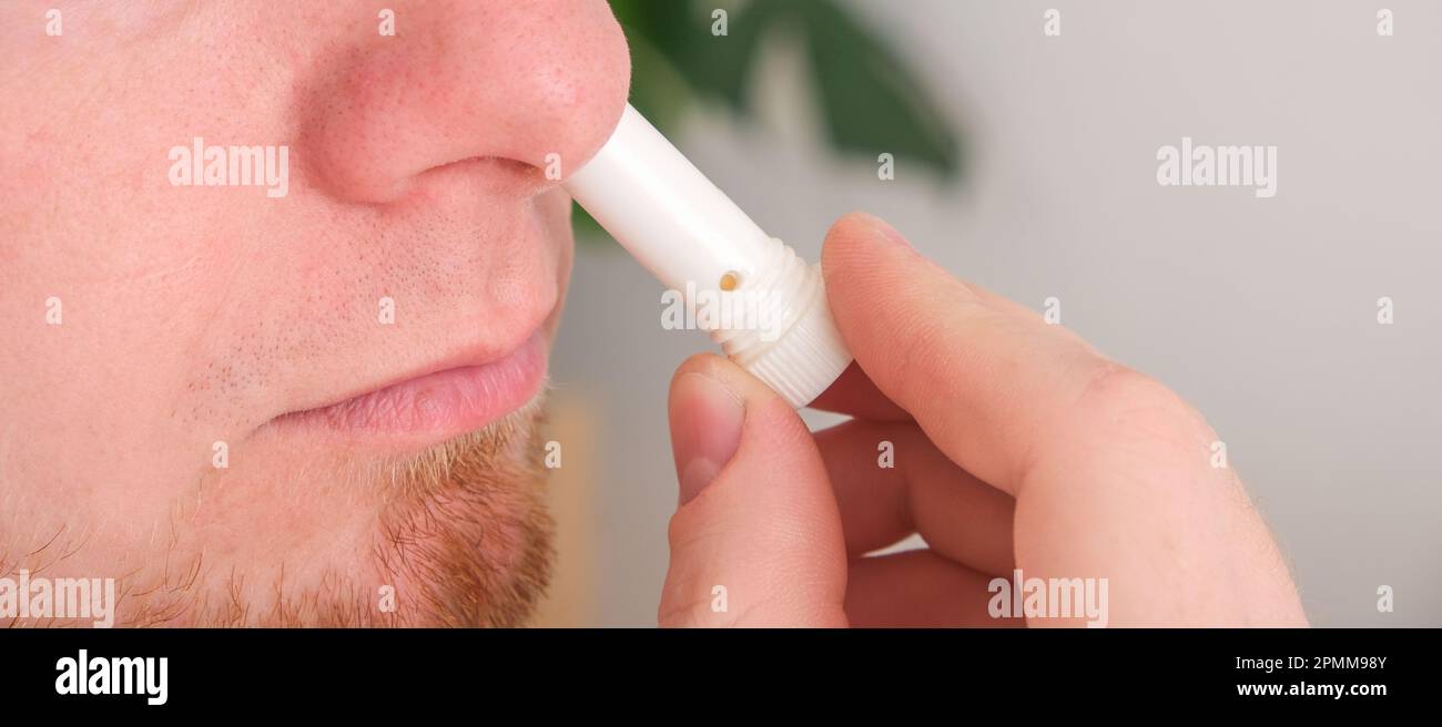 Adult man uses nasal stick inhaler to smell for relieve dizzy and faint ...