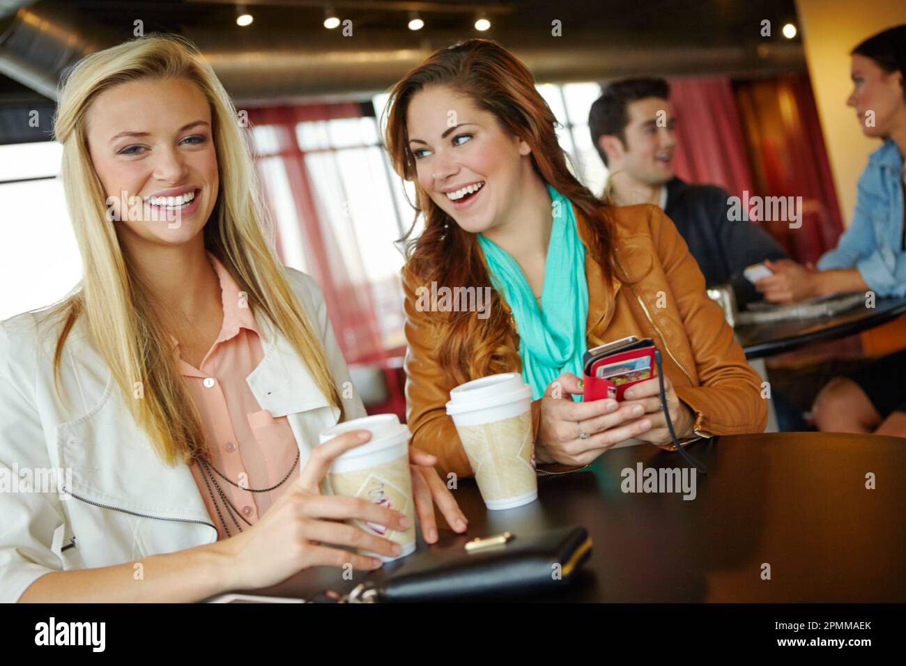 Doing some catching up. Two attractive young women having coffee ...