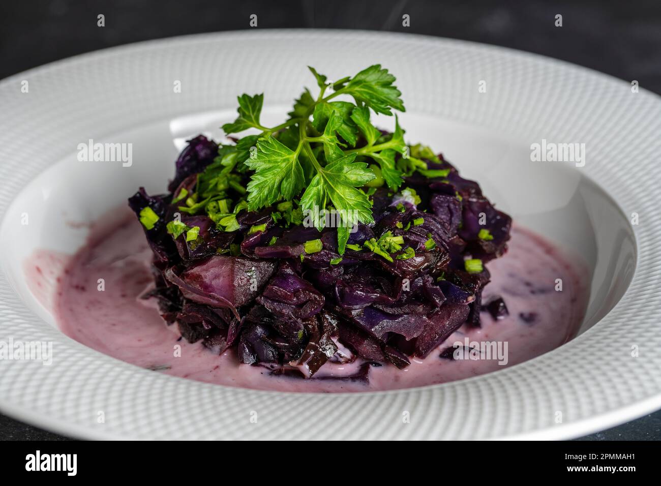 Fried red cabbage stewed in mulled wine served in white plate ...