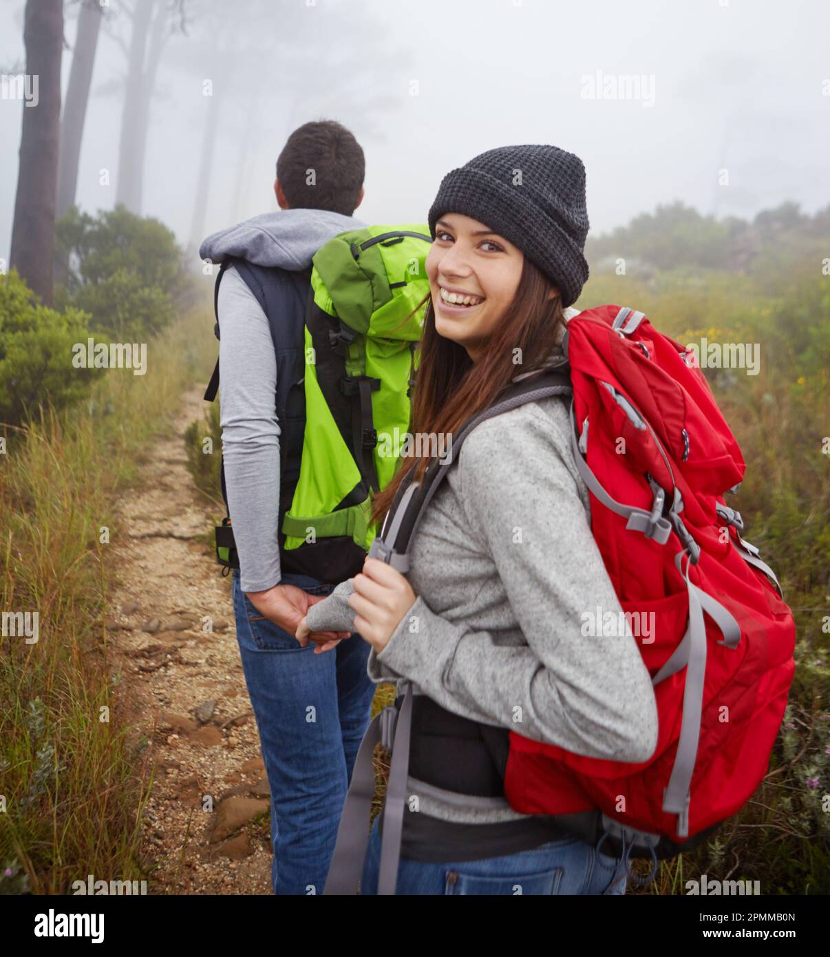 Hitting the trail. Portrait of a beautiful young woman hiking along a trail with her boyfriend ...