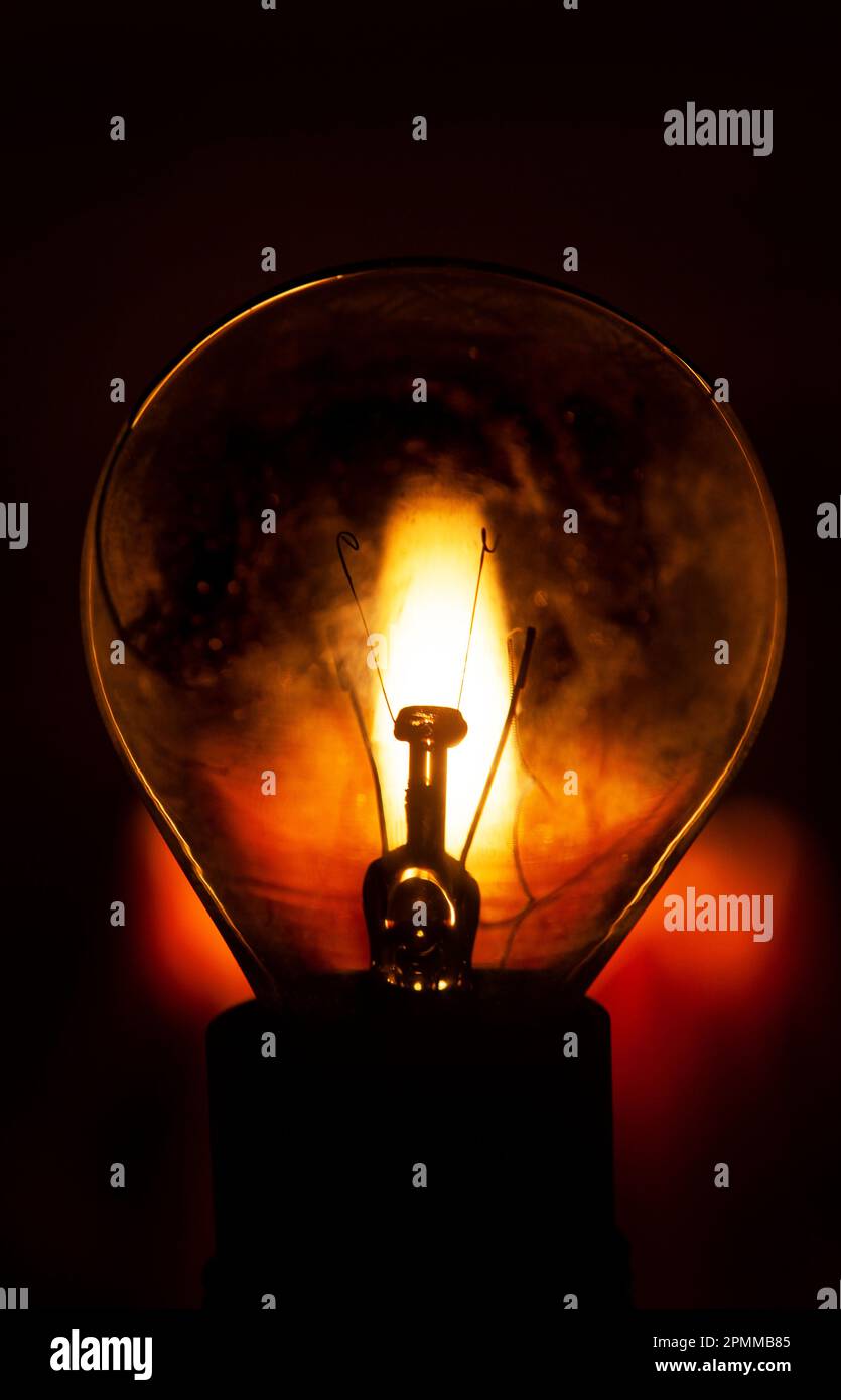 Broken lightbulb lit by candle behind, South Africa load shedding Stock ...
