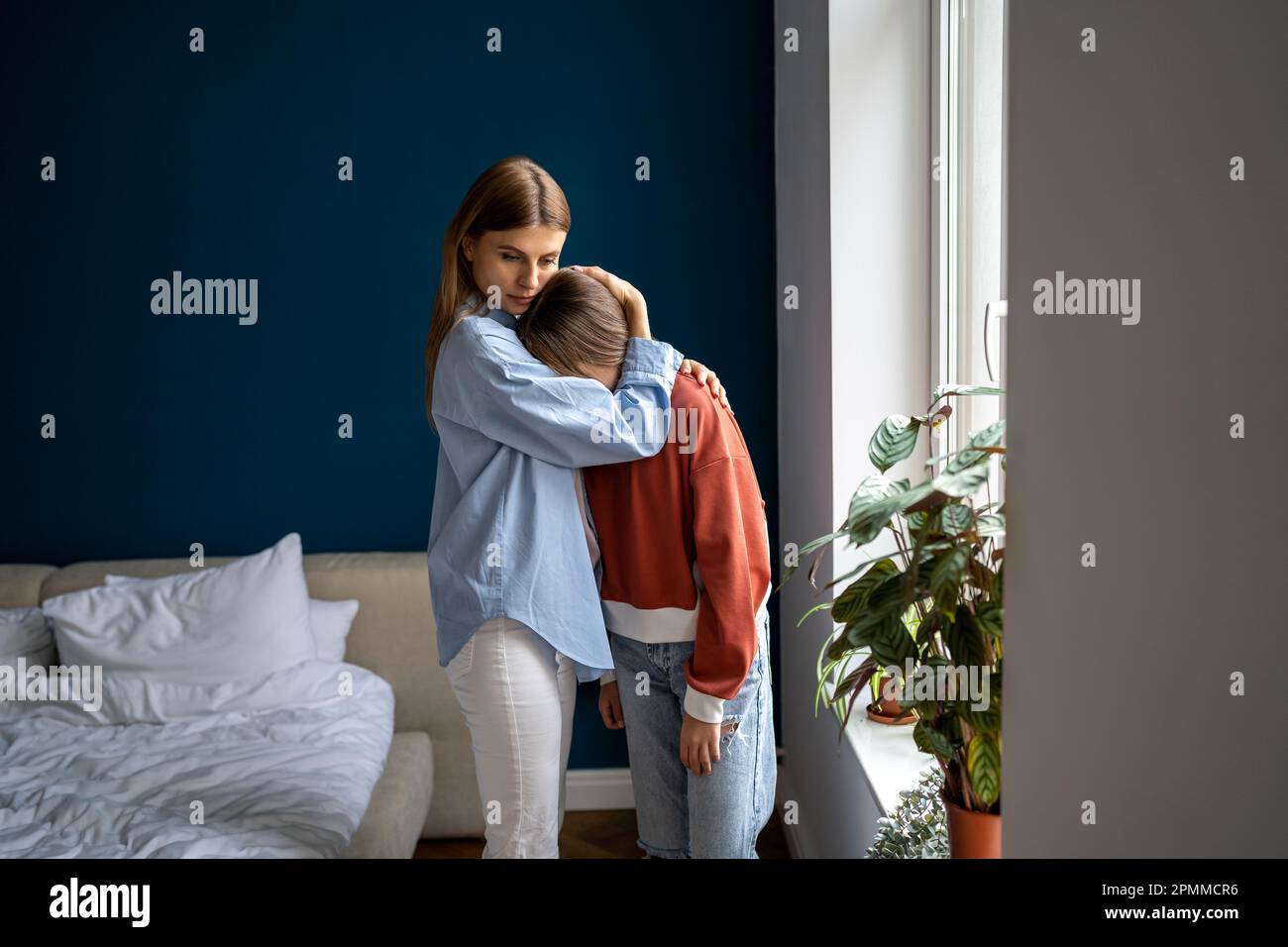 Loving older sister embracing upset crying teen girl, mother hugging supporting teenage daughter ...