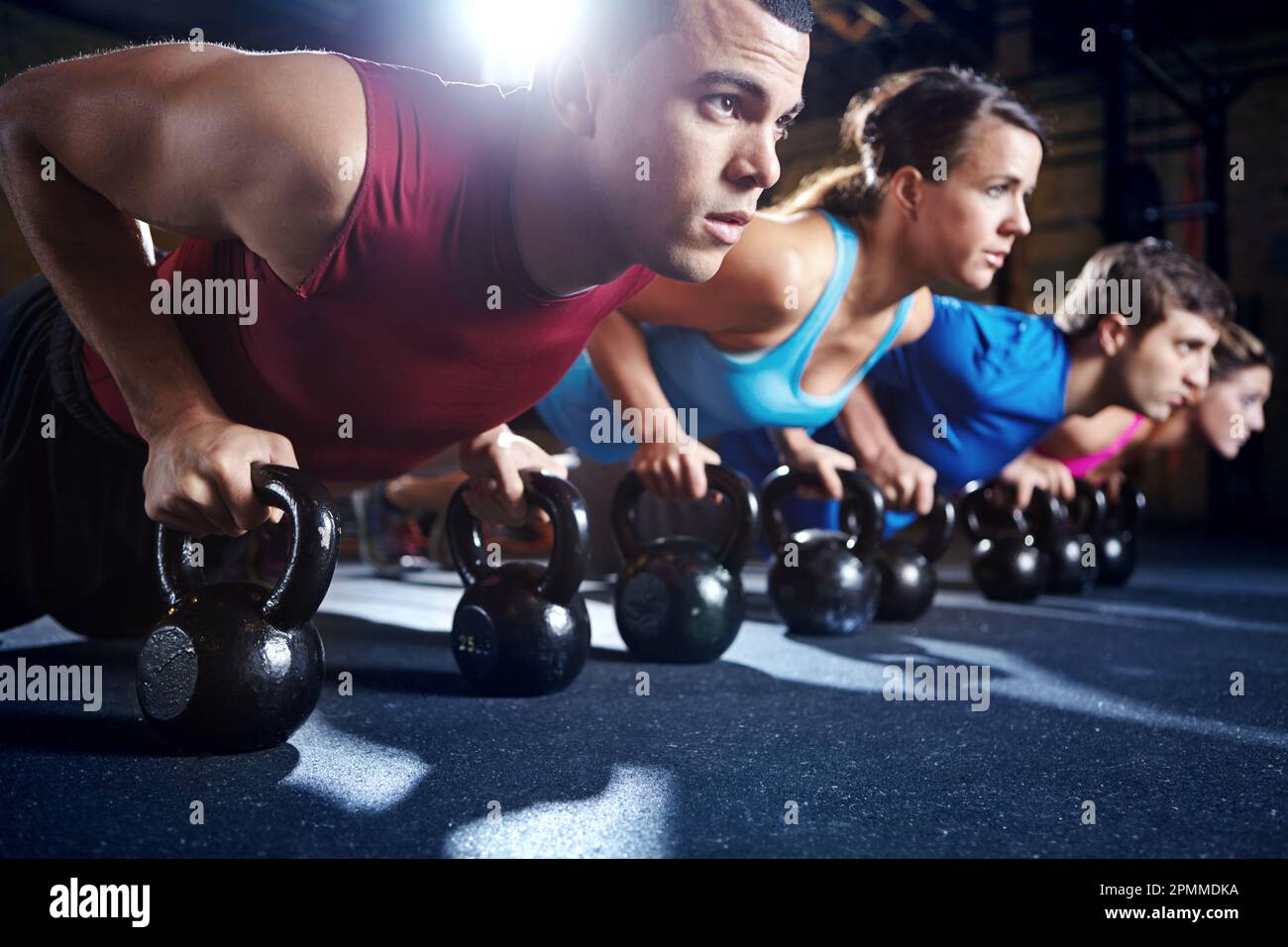 Strengthening their muscles together. A group of young men and women ...
