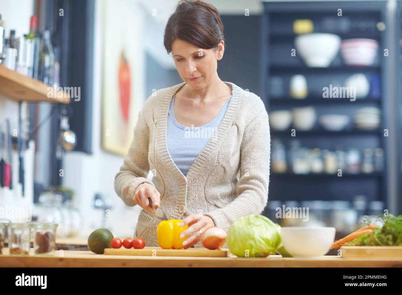 Cooking well doesnt mean cooking fancy. an attractive woman chopping ...
