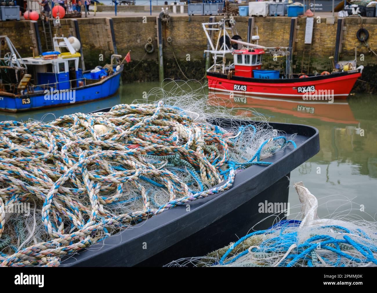 Close-up of fishing nets & ropes with fishing boats in background at ...