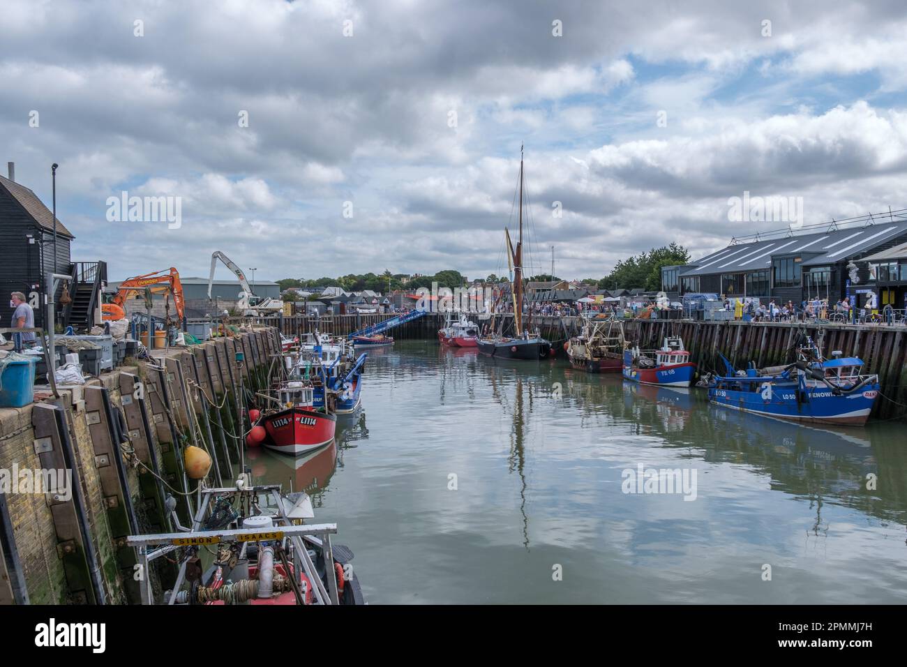 Small fishing boats tied up along the dock at Whitstable Harbour, North ...