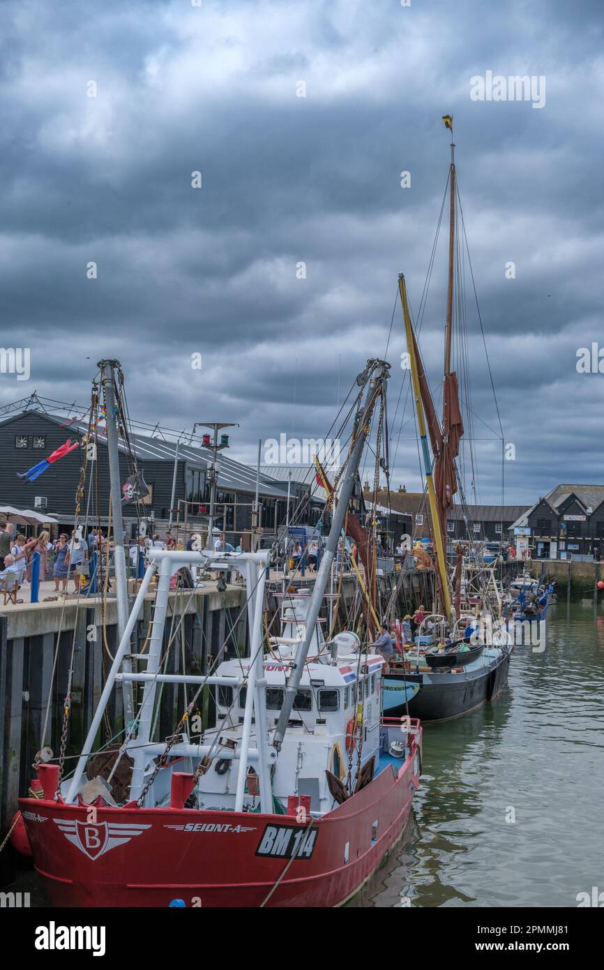 Small fishing boats tied up along the dock at Whitstable Harbour, North ...