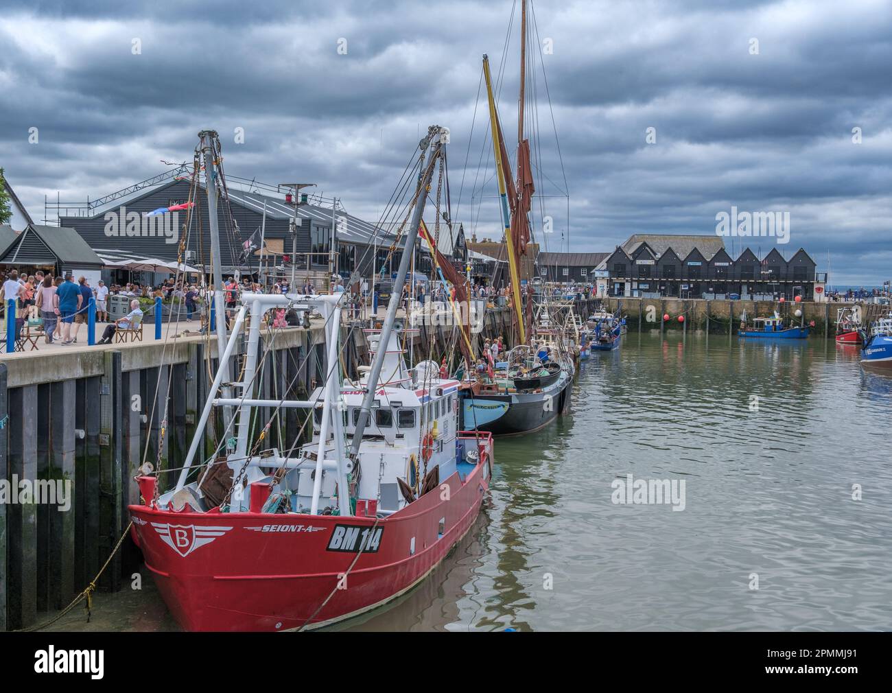 Small fishing boats tied up along the dock at Whitstable Harbour, North ...