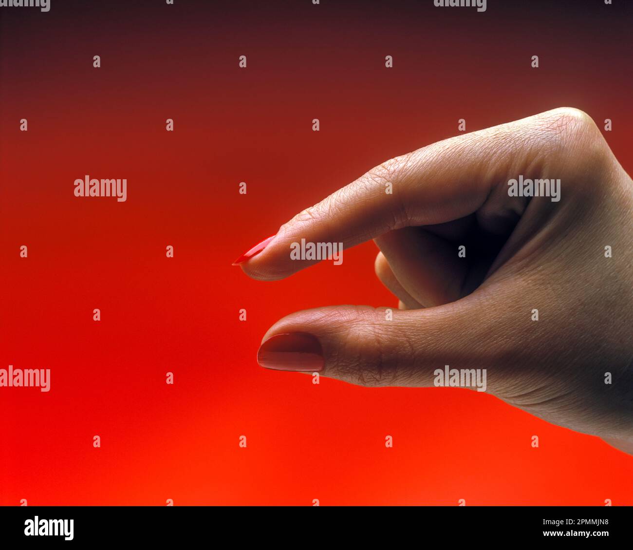 CAUCASIAN WOMANS HAND PINCHING AIR ON RED BACKGROUND Stock Photo - Alamy