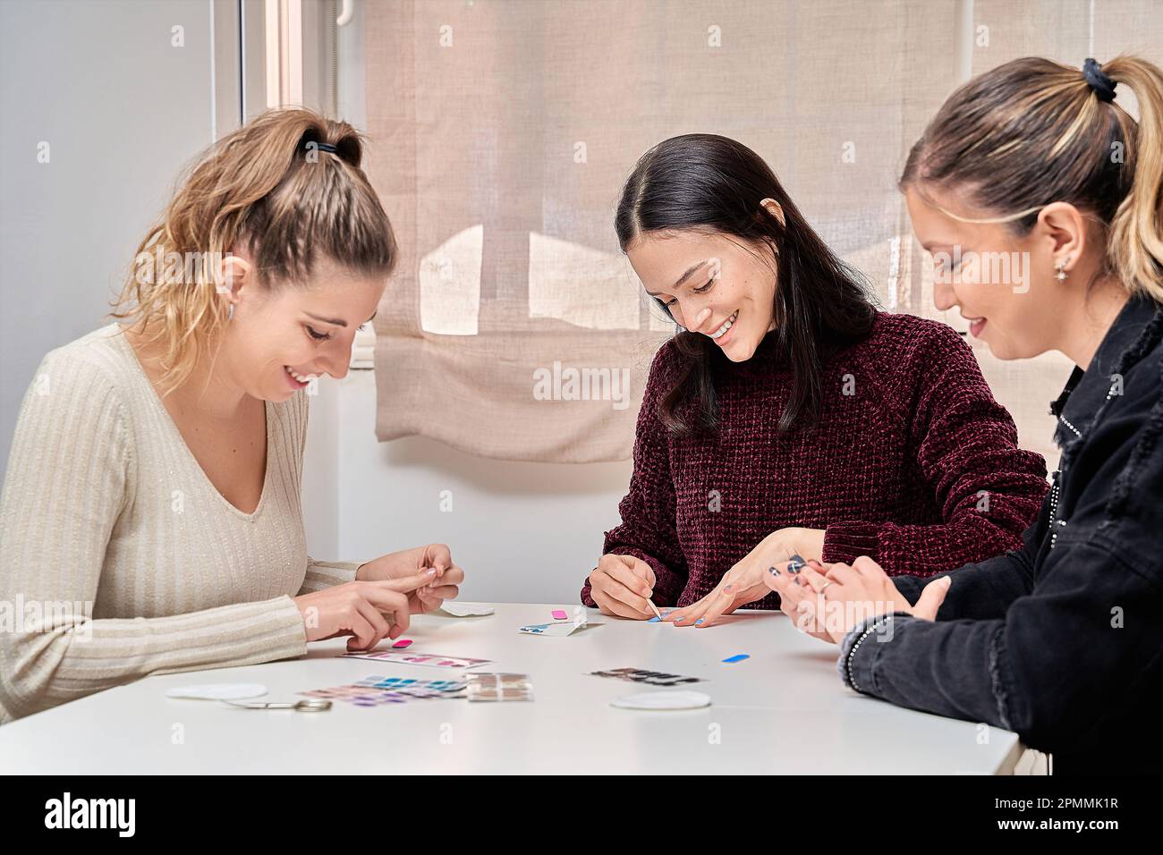 Female friends having fun while doing their nails together. Manicure ...