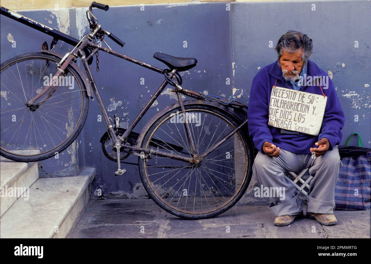 Argentina, Salta. Beggar sitting next to a bike Stock Photo - Alamy
