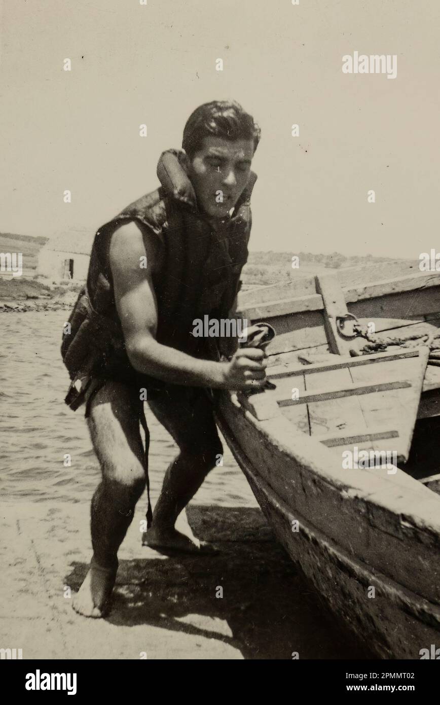 Rome, Italy may 1951: A young boy pushes a small wooden boat into the ...