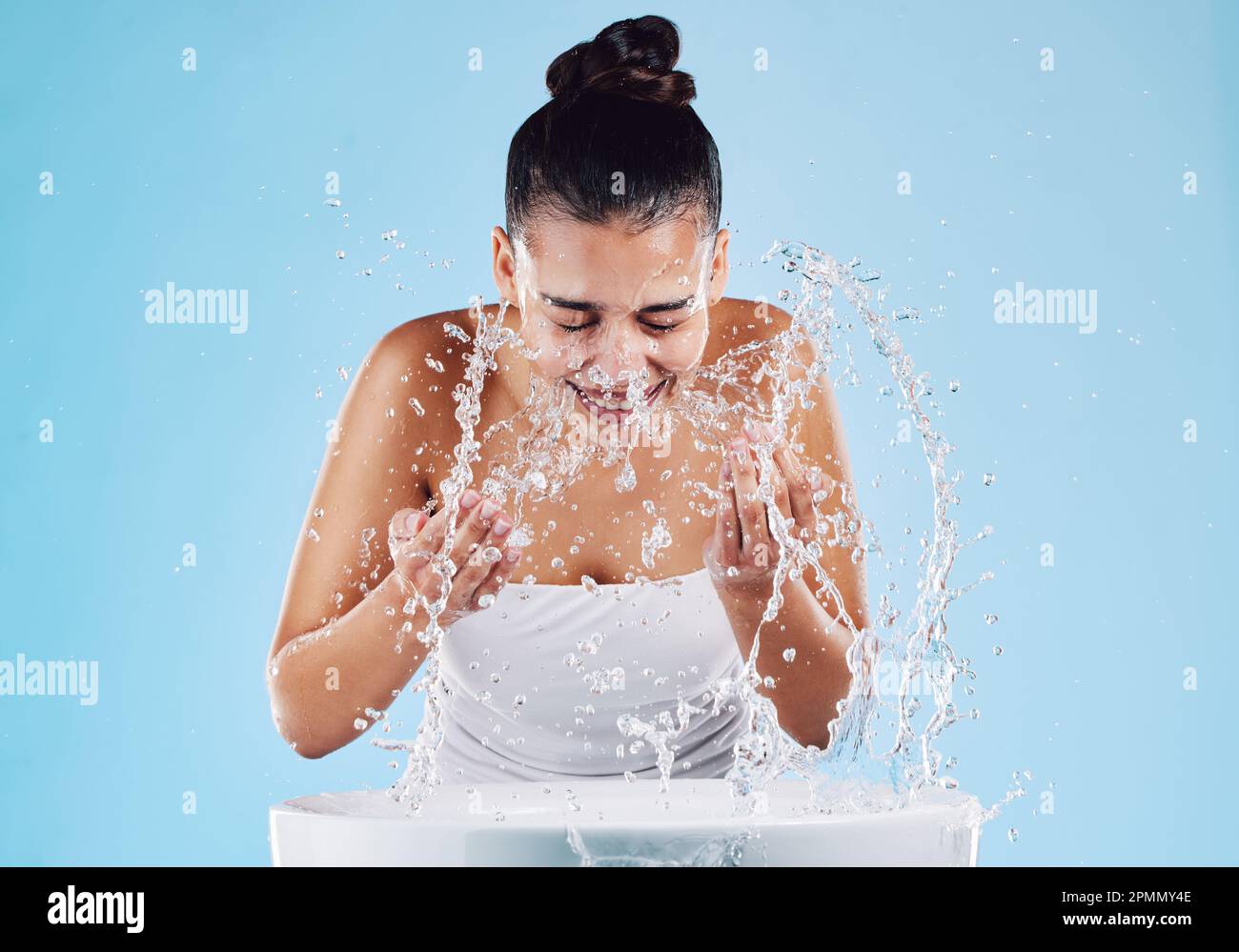 Sink, water splash and skincare of a woman washing face for natural ...