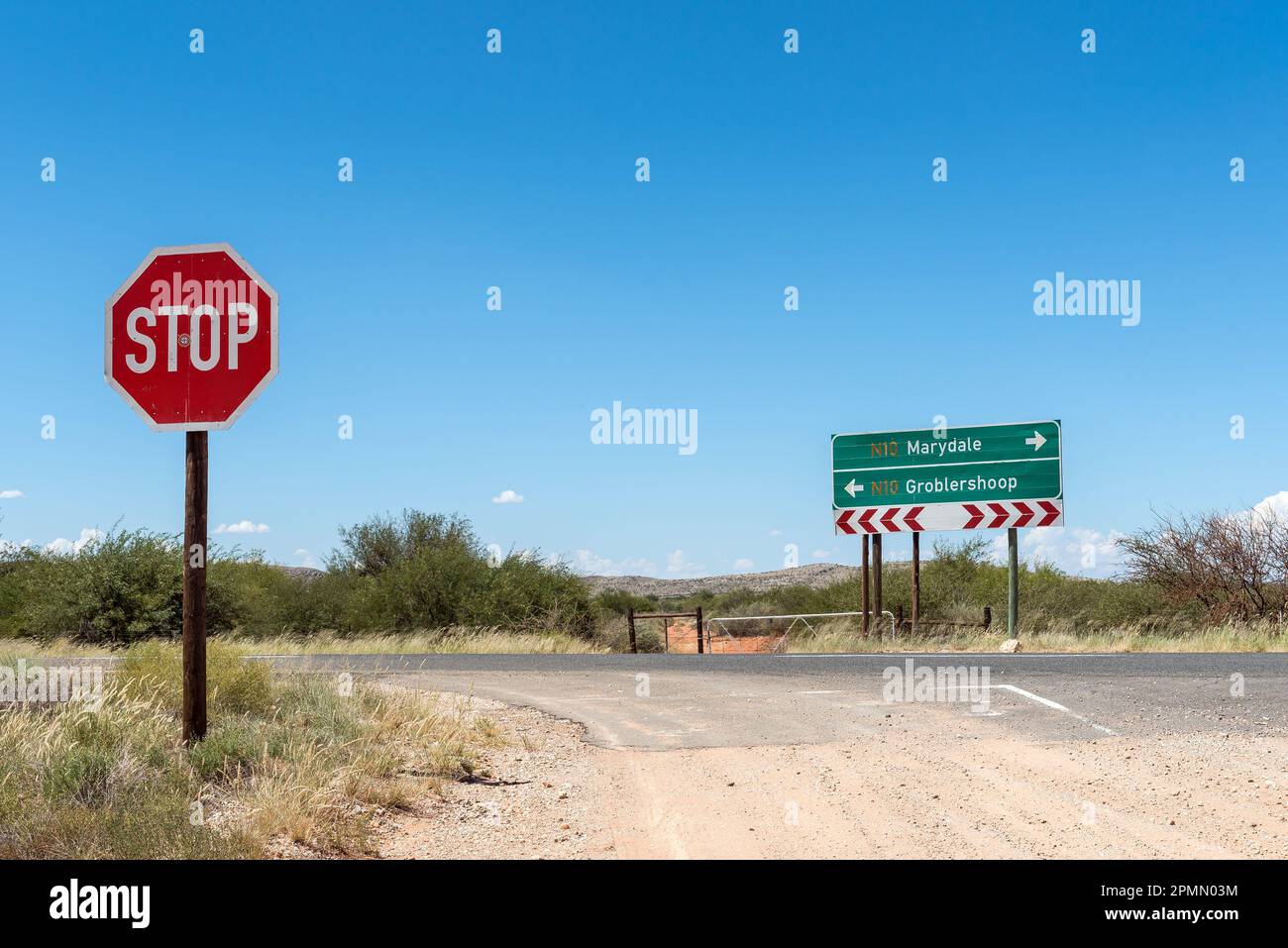 A directional sign and a stop sign at the junction of the ...