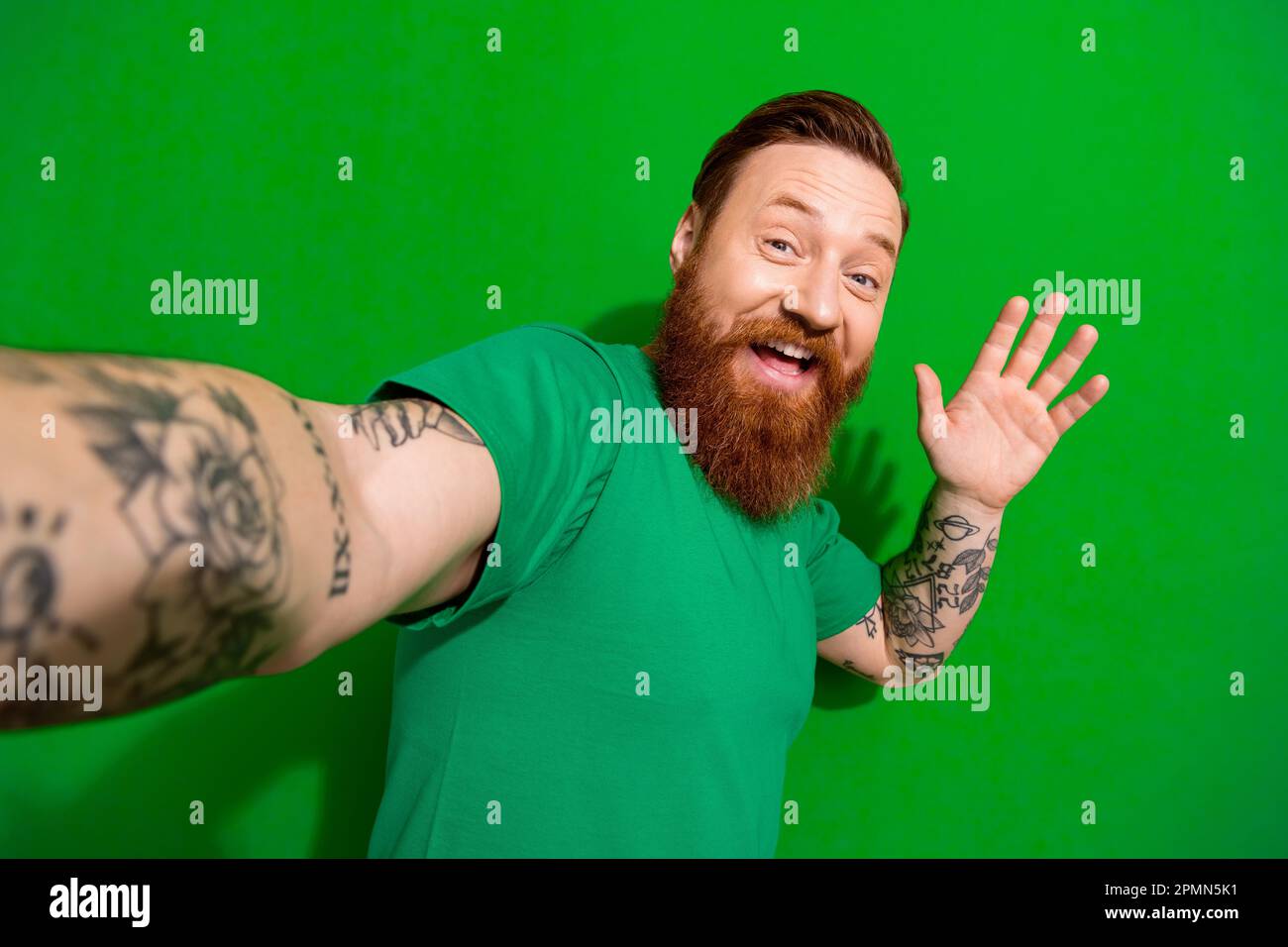 Photo of excited funky guy dressed t-shirt recording vlog waving arm ...
