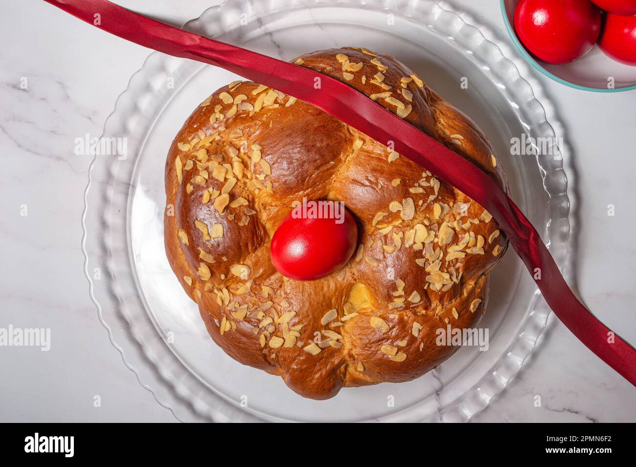 Easter traditional bread, greek tsoureki and red eggs on a table Stock ...