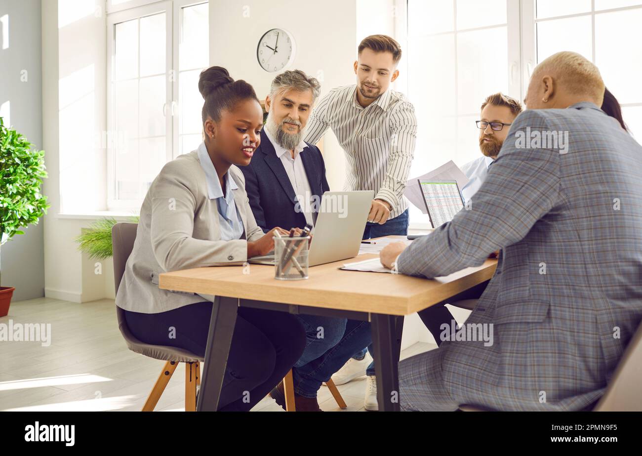 Woman employee showing something to her colleagues on the monitor ...