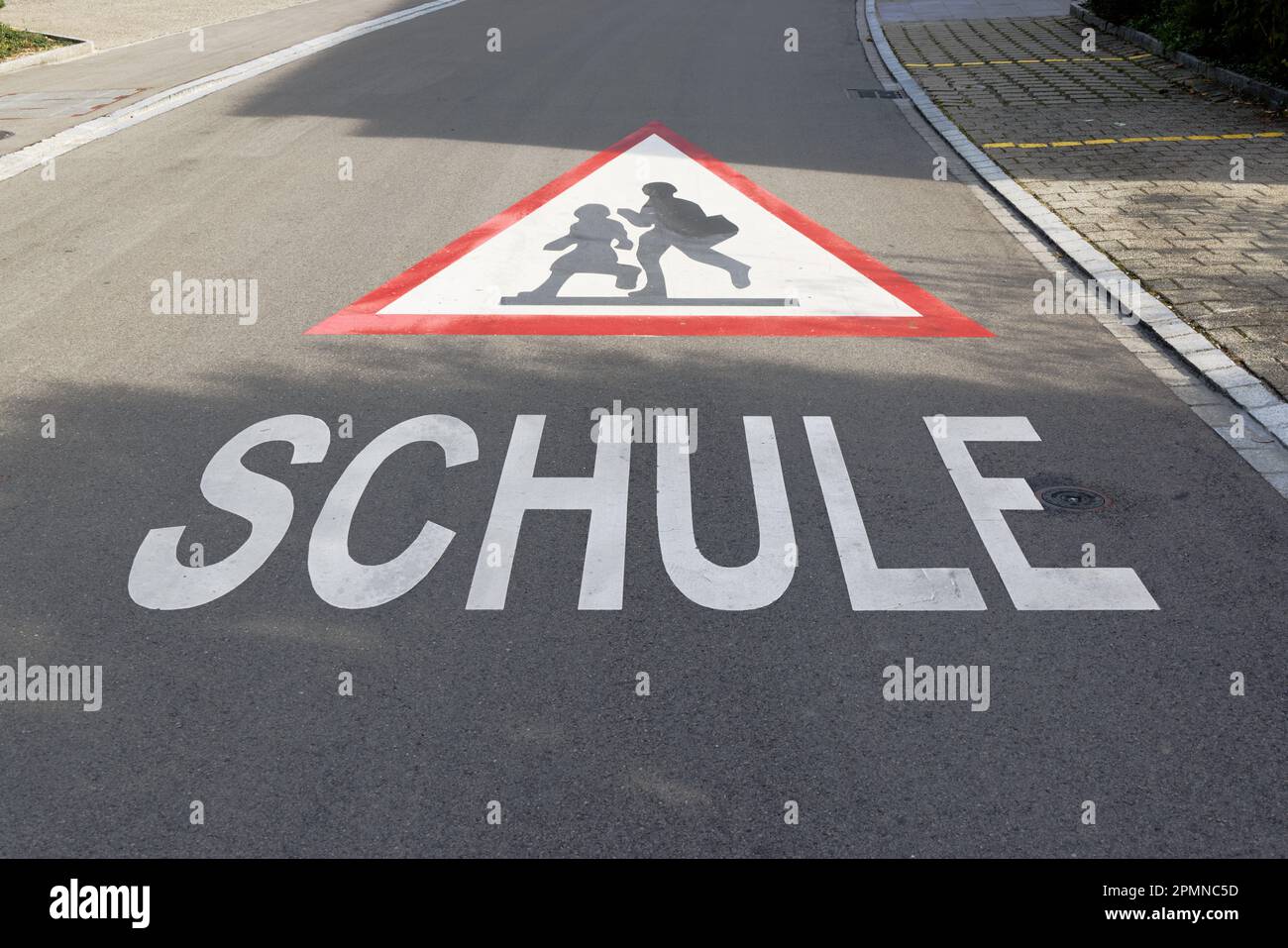 red and white attention school sign painted on concrete road. car ...