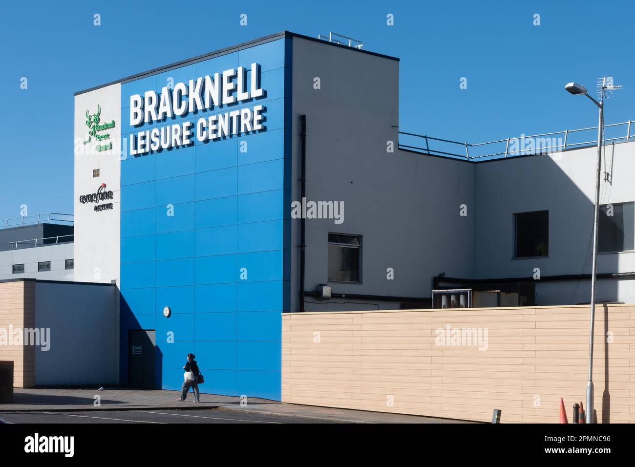 Bracknell Leisure Centre in Berkshire, England, UK, exterior view with a young woman walking ...