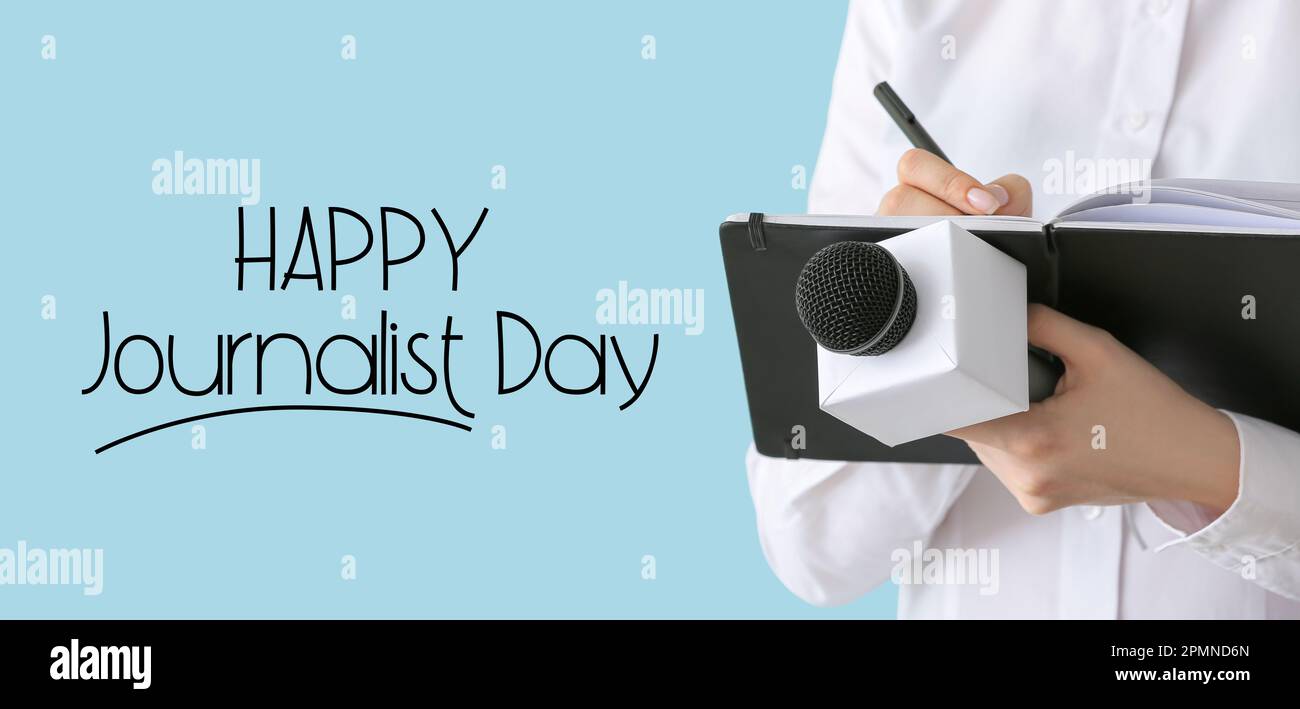 Woman with microphone writing in notebook against light blue background ...