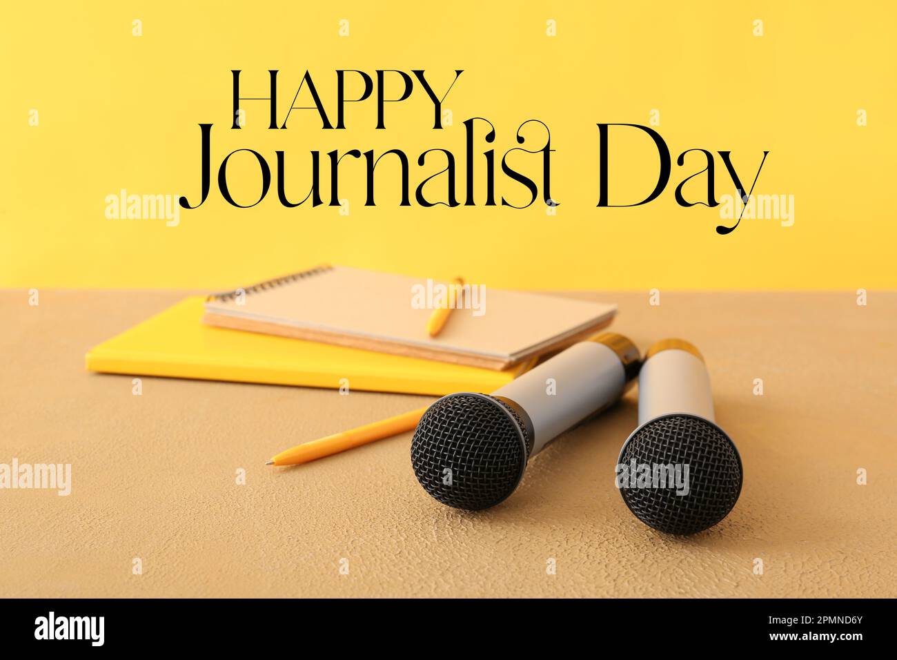 Microphones and notebooks on table against yellow background. Happy ...