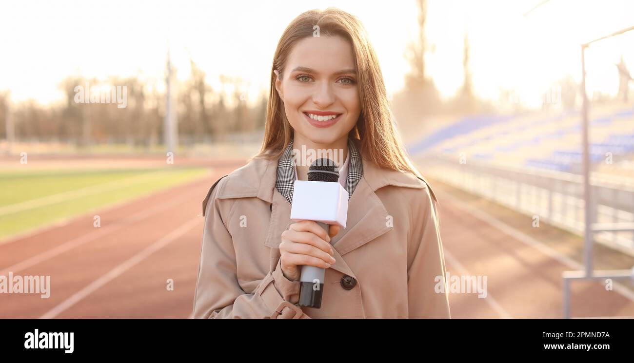 Beautiful reporter with microphone at the stadium Stock Photo - Alamy